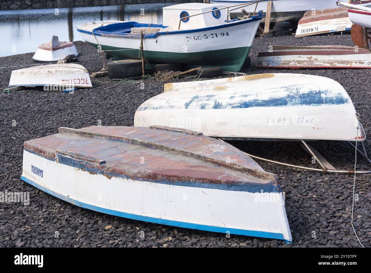 Small boats on shore showing signs of weathering. Rowing boats and ...
