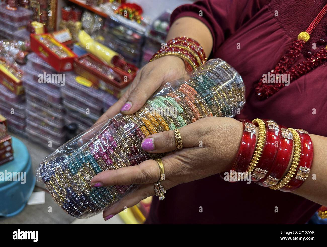 September 4, 2024: A woman displays colorful bangles for selling for ...
