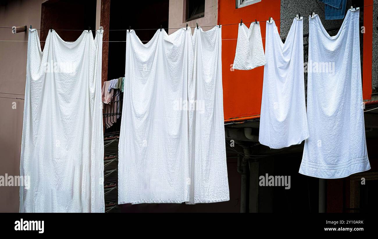 Freshly washed white sheets hanging on clothesline outside Stock Photo - Alamy