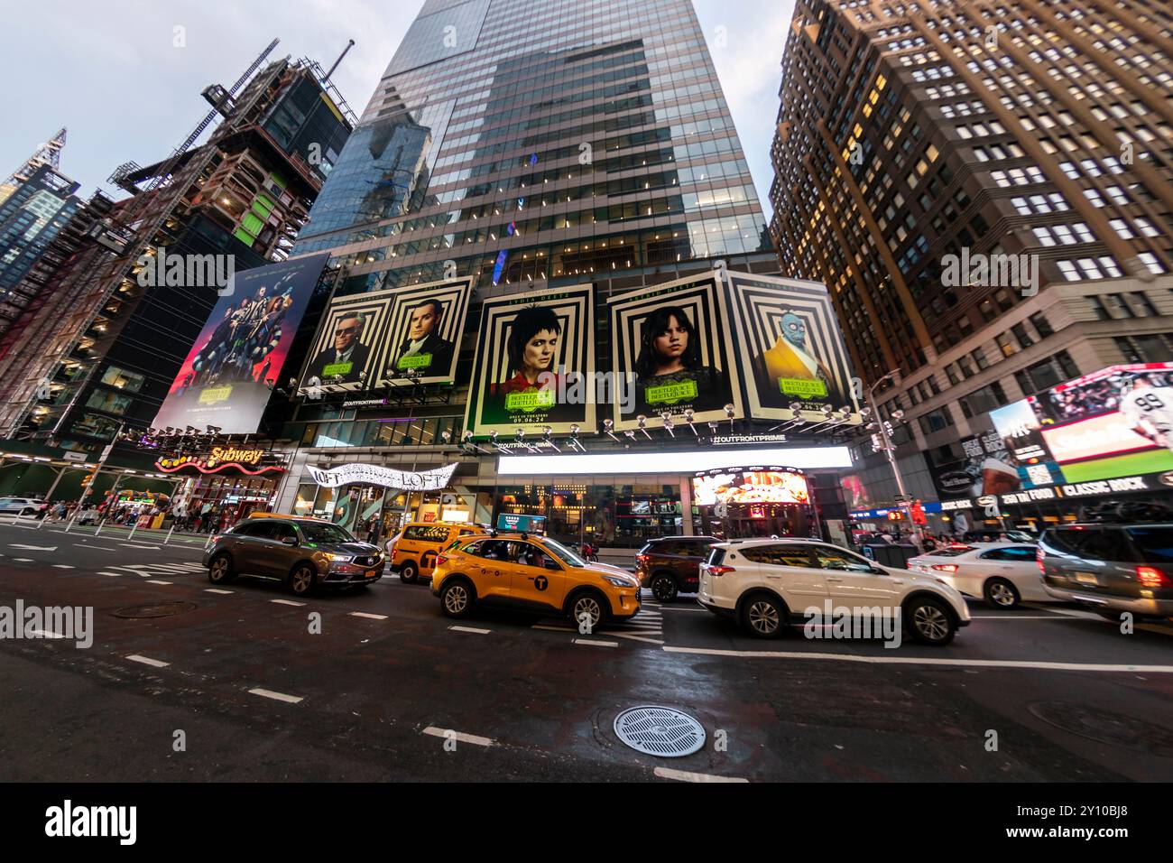 Hordes of people cross West 42nd Street under advertising for the ...