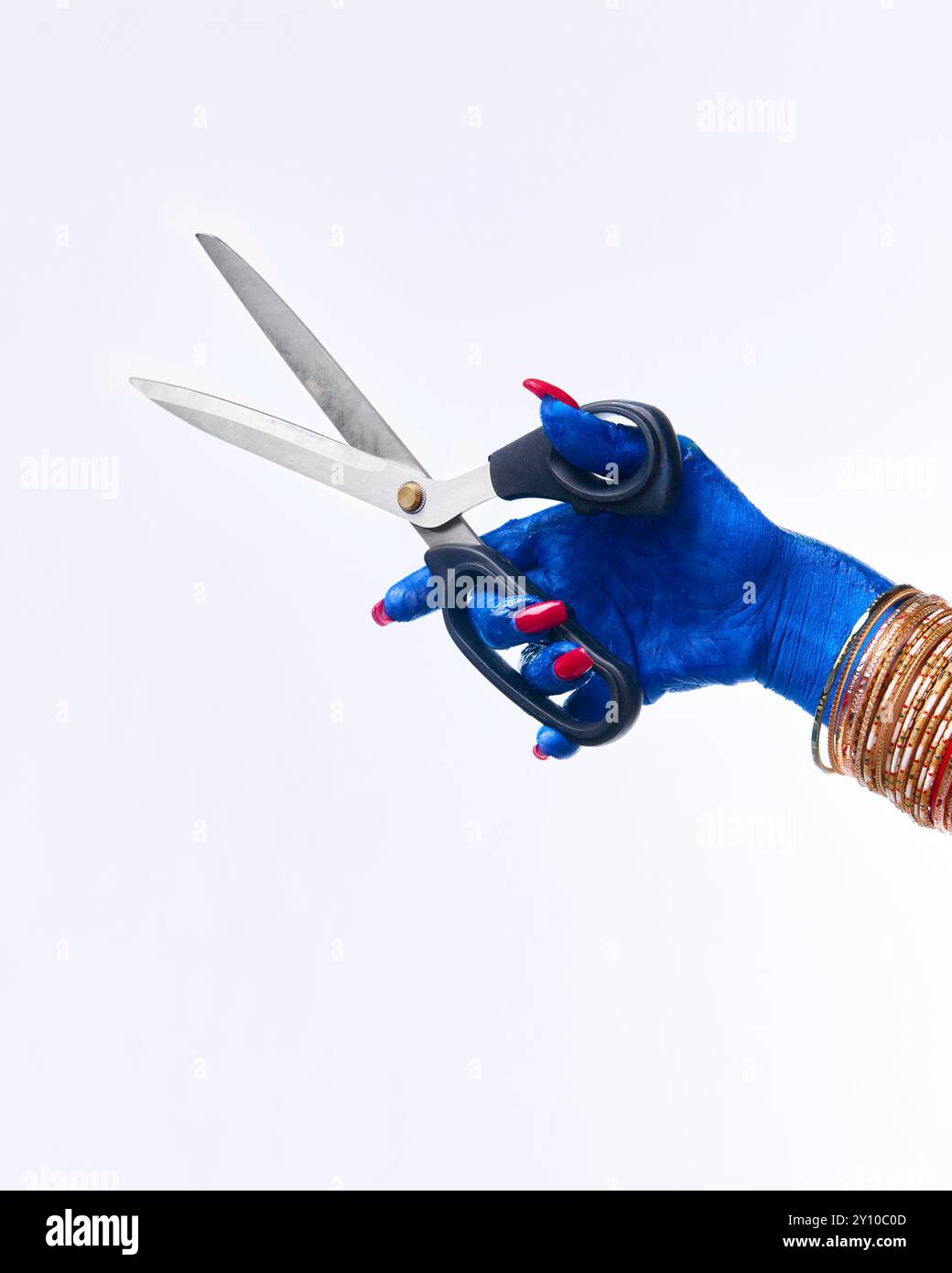 Witch's, monster's blue hand with long, vivid nail art holds scissors ...