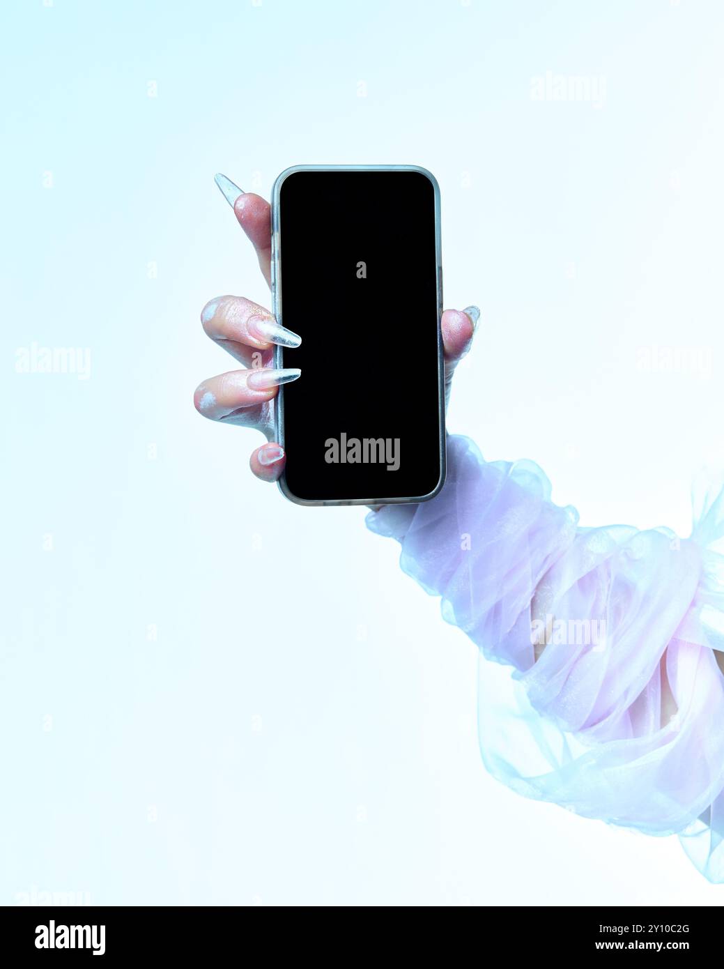Hand of spooky white ghost holding smartphone with blank screen against ...