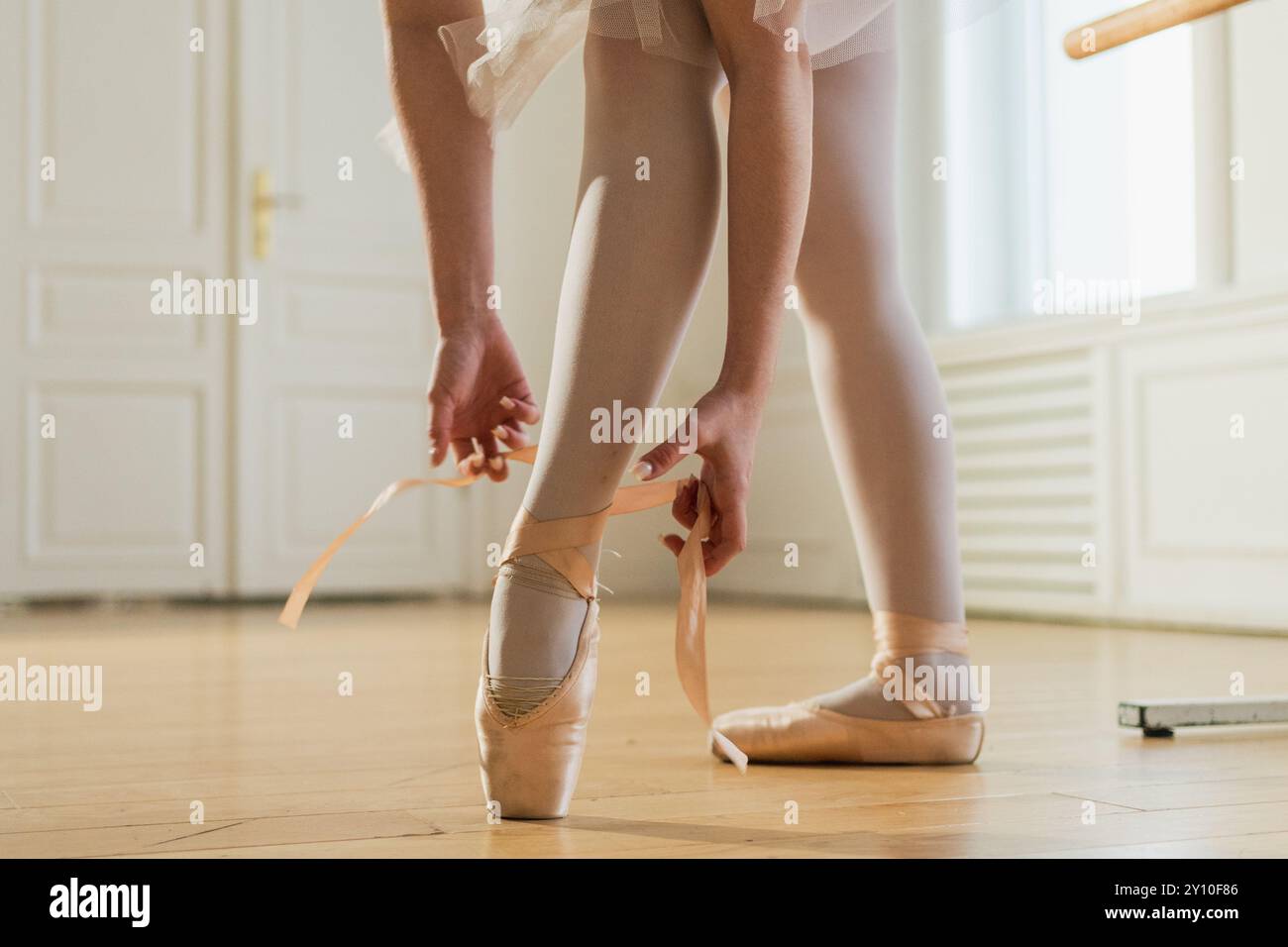 Ballerina puts on pointe shoes on leg in dance class. Classical ballet ...