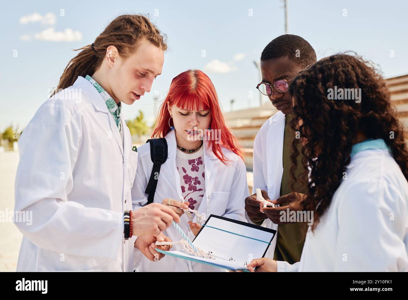 Diverse group of young medical students in white lab coats standing in ...