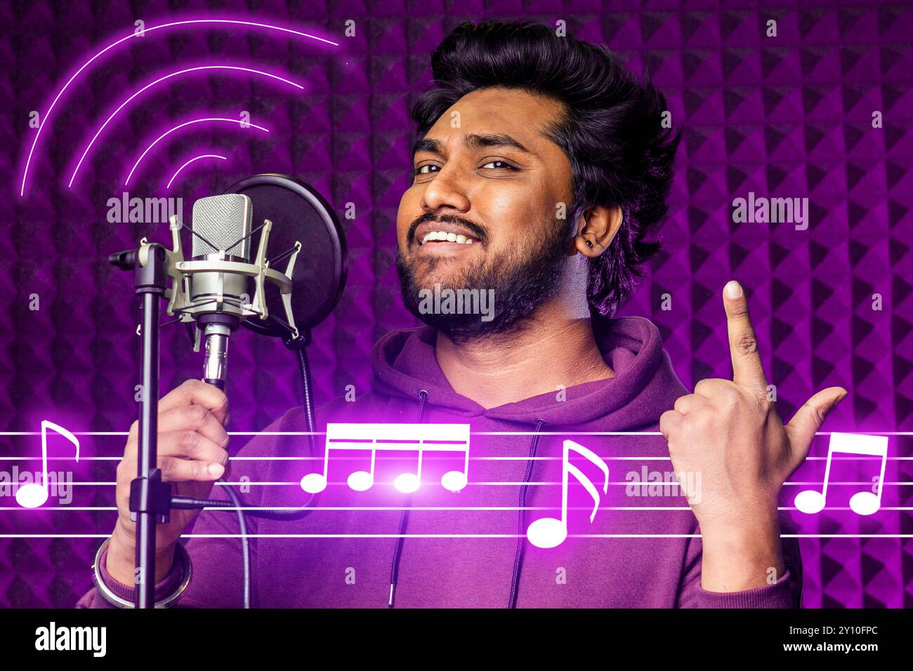 A man is singing into a microphone with a purple background Stock Photo ...