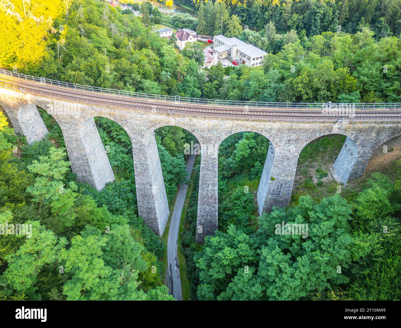 The Zampach stone railway bridge arches over lush greenery, connecting ...