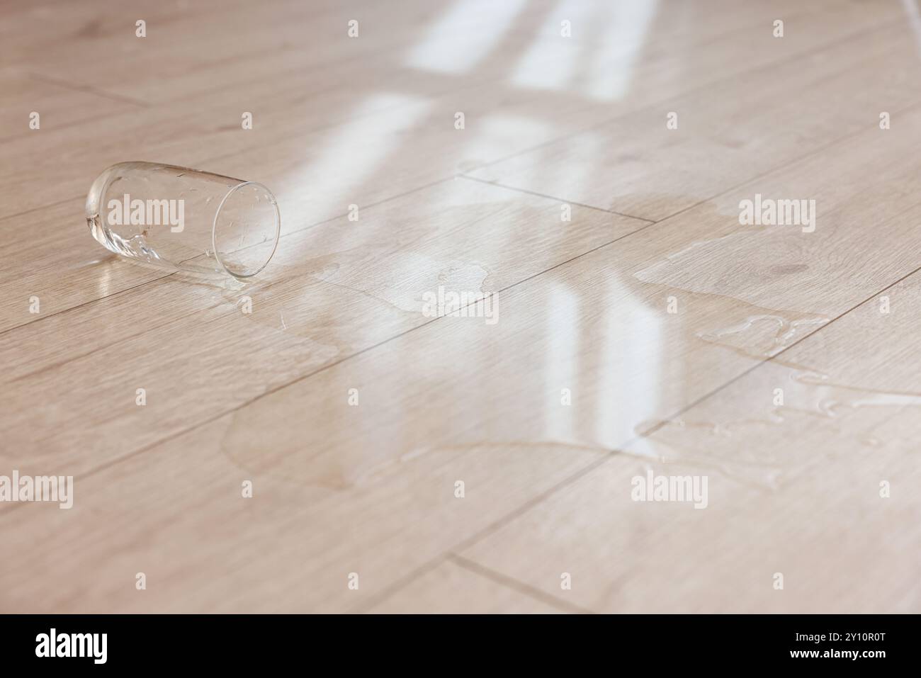 Glass with spilled drink on wooden floor Stock Photo - Alamy