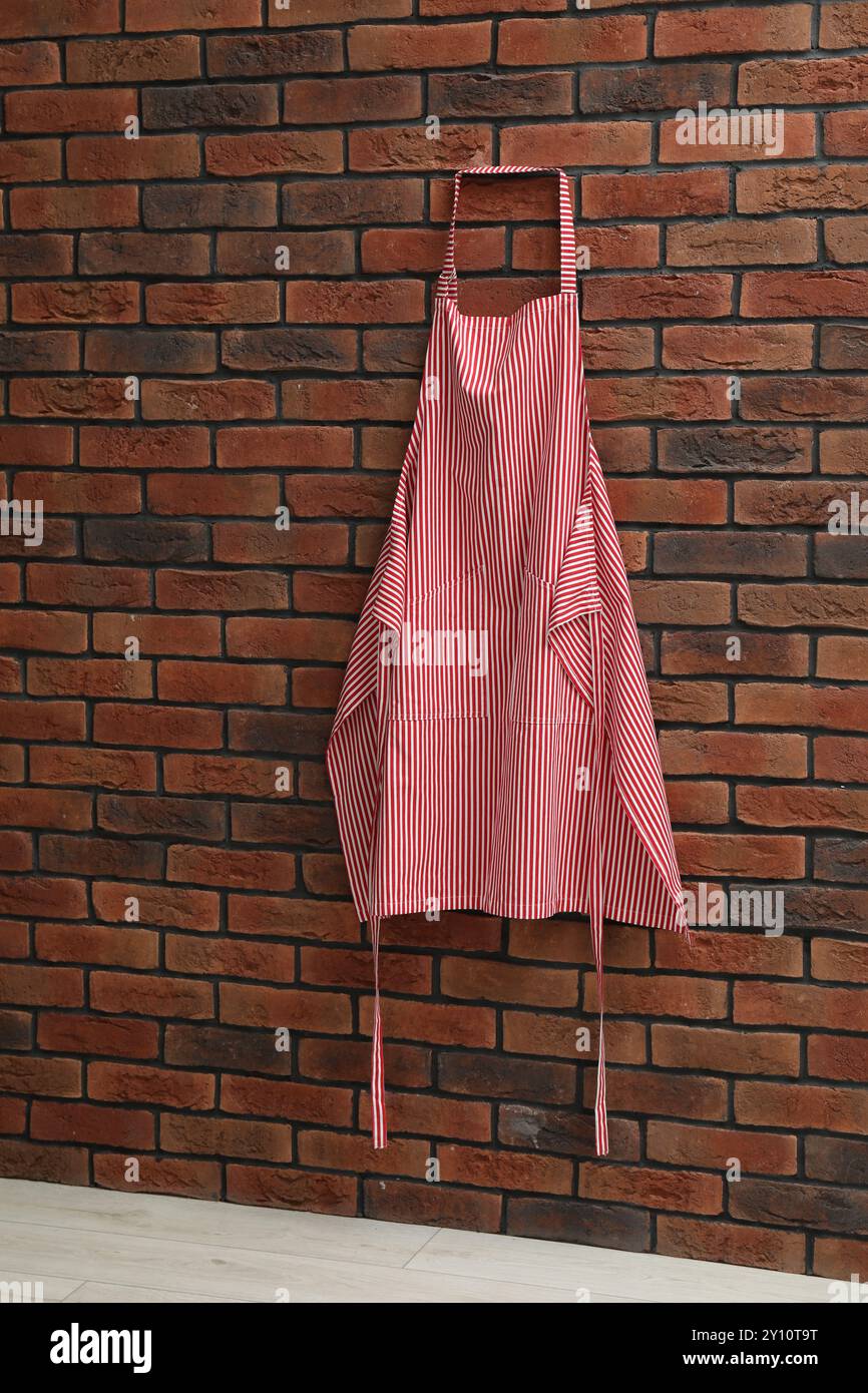 One chef's apron hanging on brick wall Stock Photo - Alamy