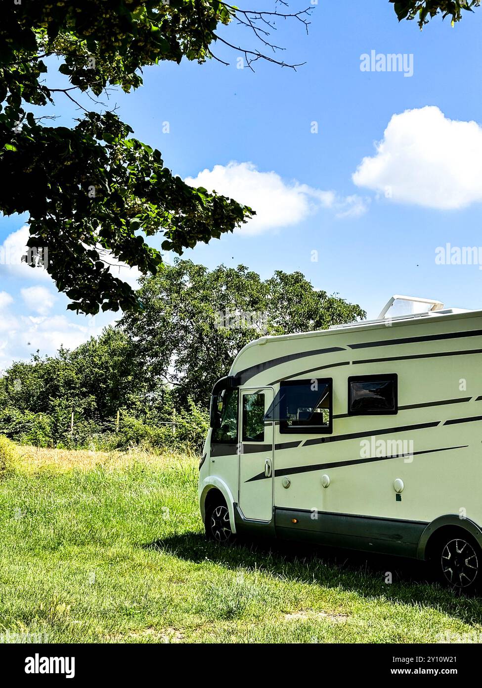 One camper van big motor home parked on the grass in country side ...