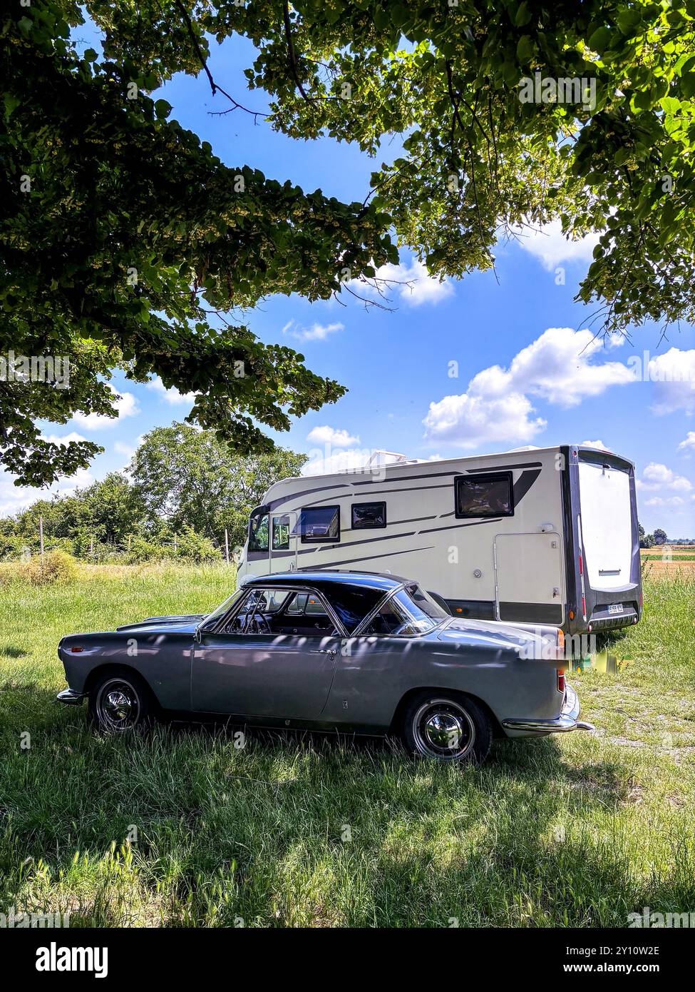 One camper van big motor home parked on the grass in country side ...