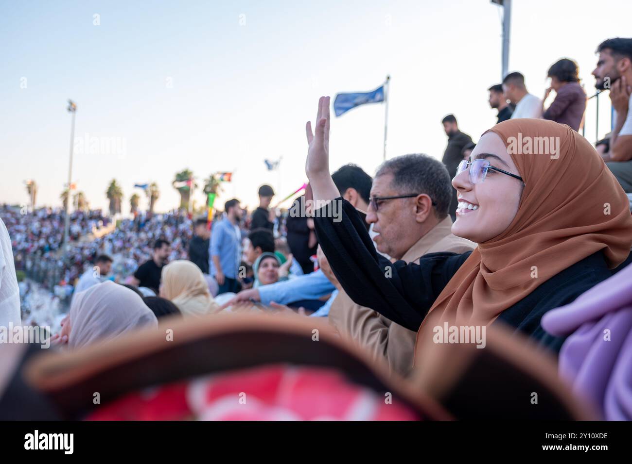 Arabic Family watching their son graduation and waving for him while ... Arabic Family watching their son graduation and waving for him while ...