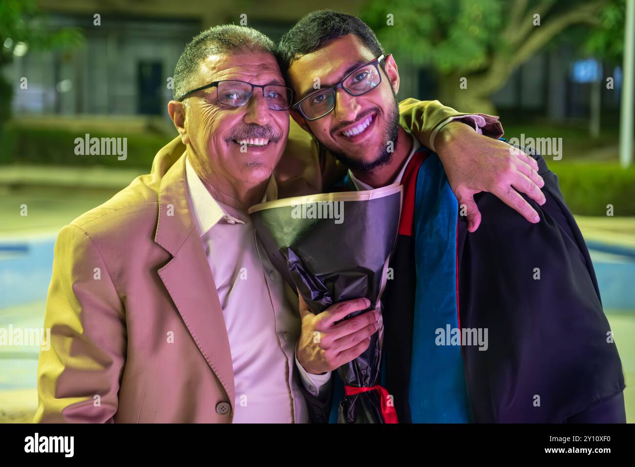 portrait for father and son celebrating graduation holding bouquet of ...