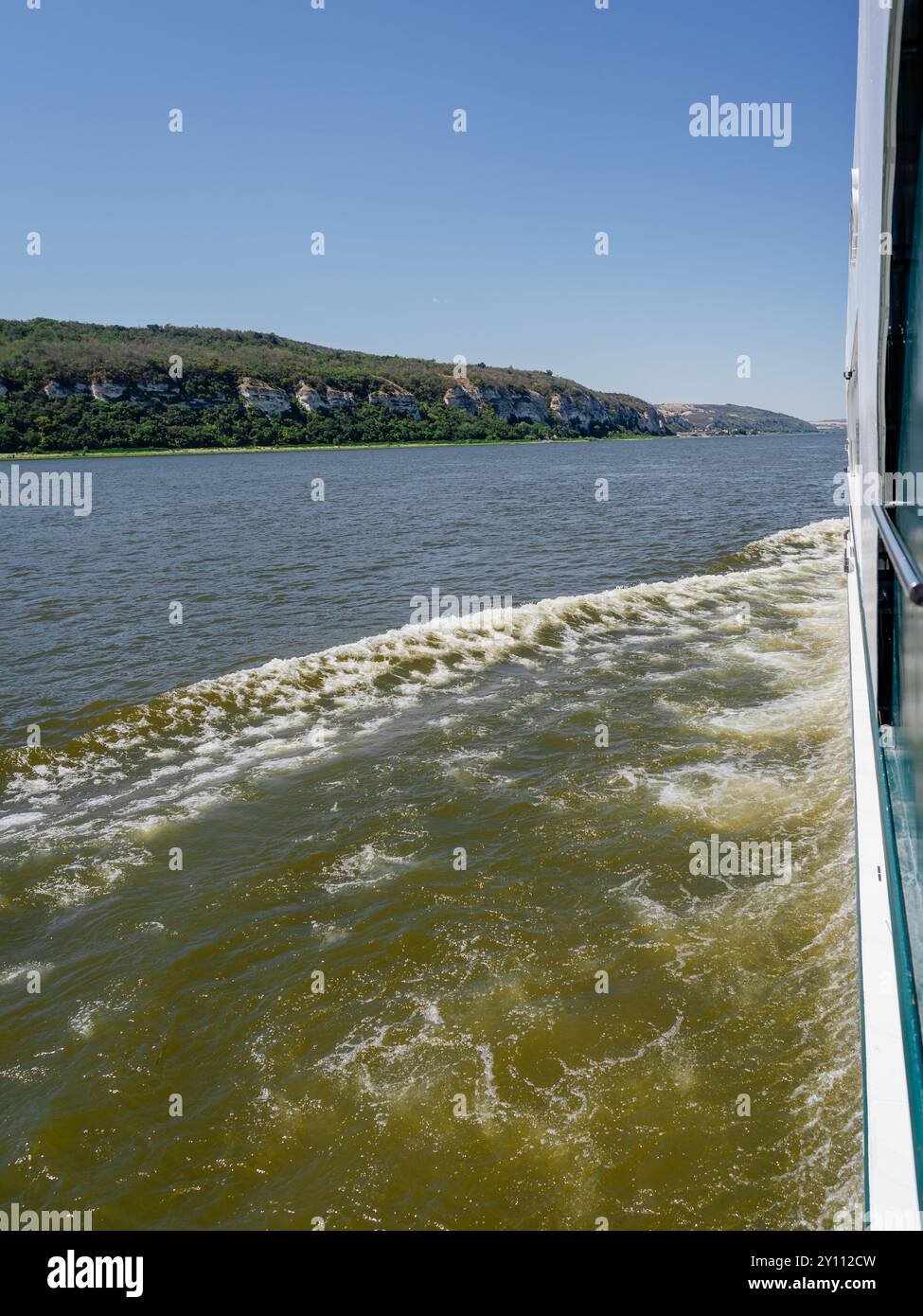 Scenic river landscape with rocky cliffs and forested hills, viewed ...