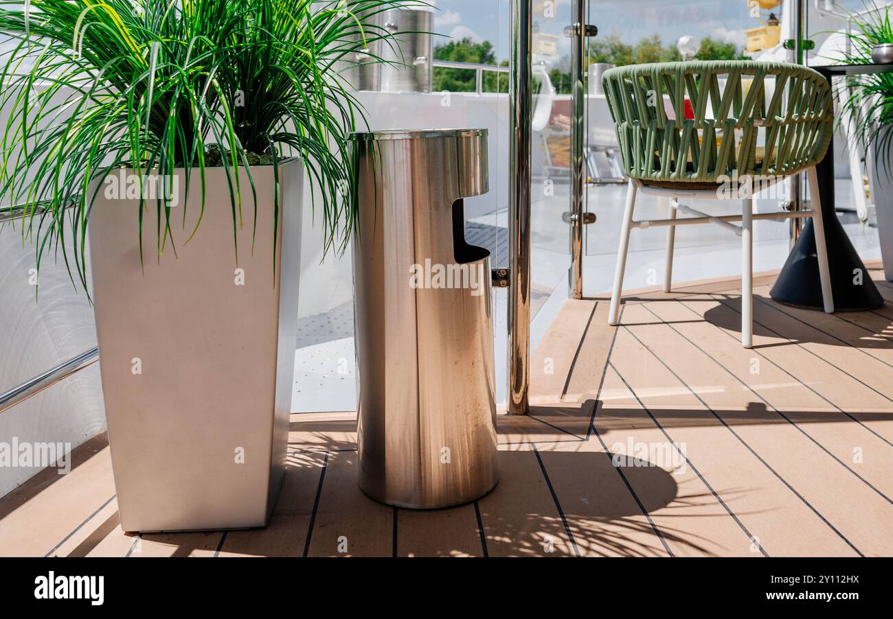 Garbage bin with green plant in the container, armchair of the ship ...