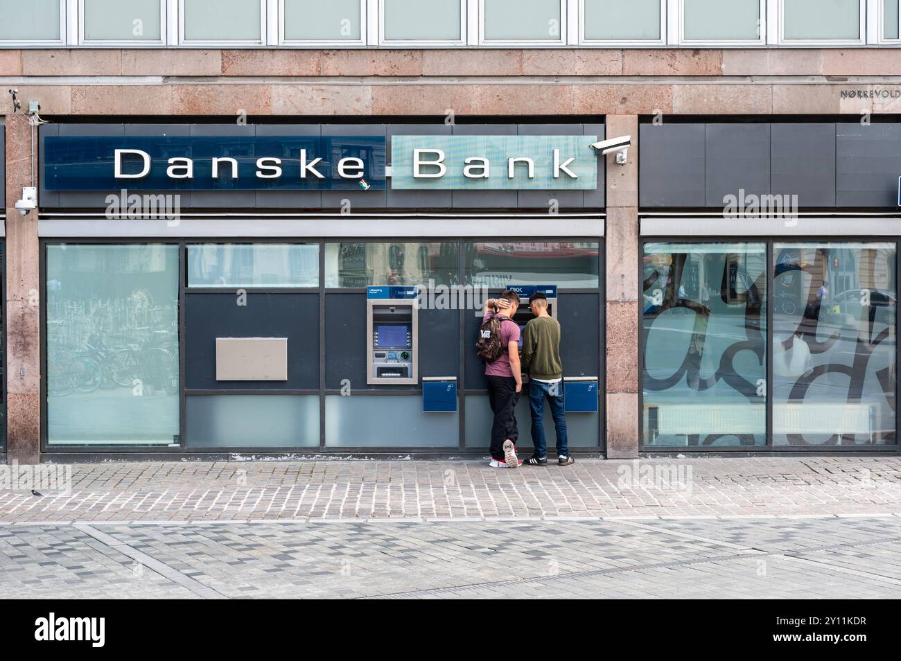 Copenhagen, Denmark, July 24, 2024 - Two young man at an ATM of the ...