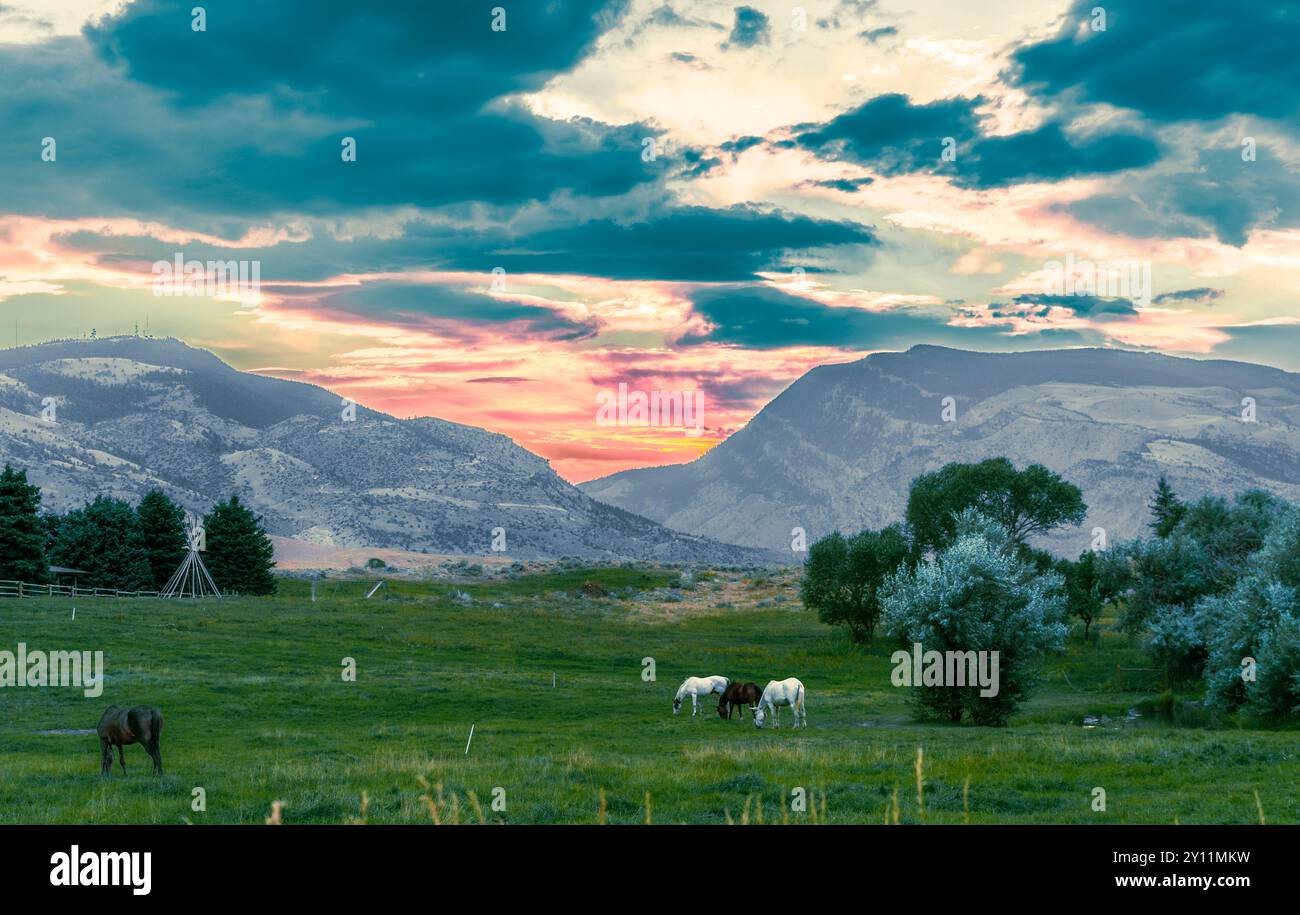 Orange sunset with blue clouds overhead shows off the mountain slopes ...