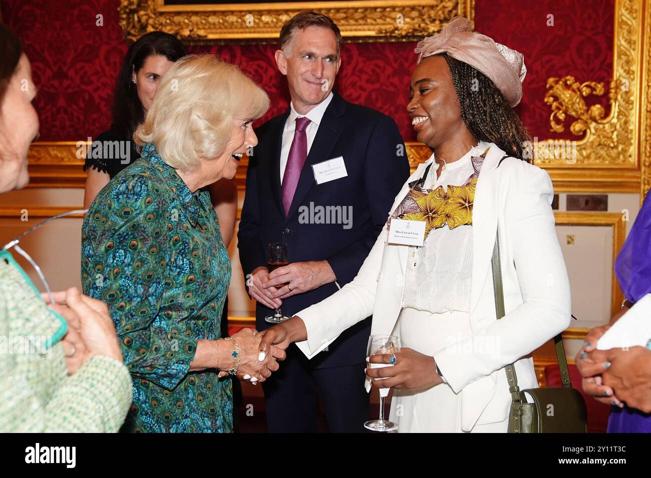 Queen Camilla (right), Patron of Book Aid International, speaks with ...