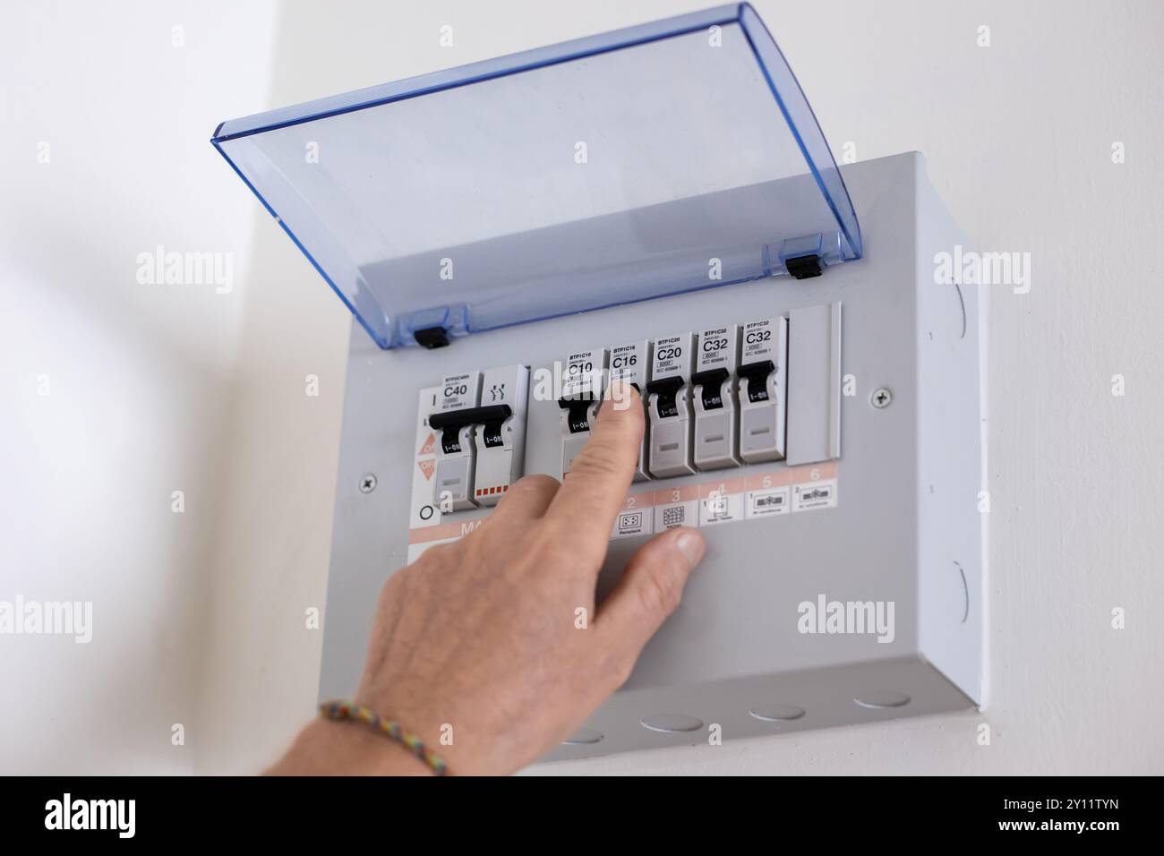 A man turns on a switch on an electrical panel in a room. Distributor ...
