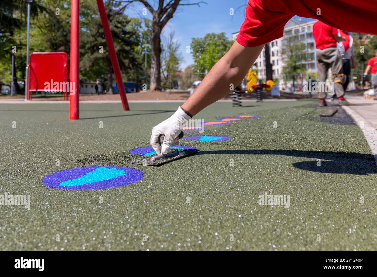 New childrens playground under construction. A mason hand with trowel ...
