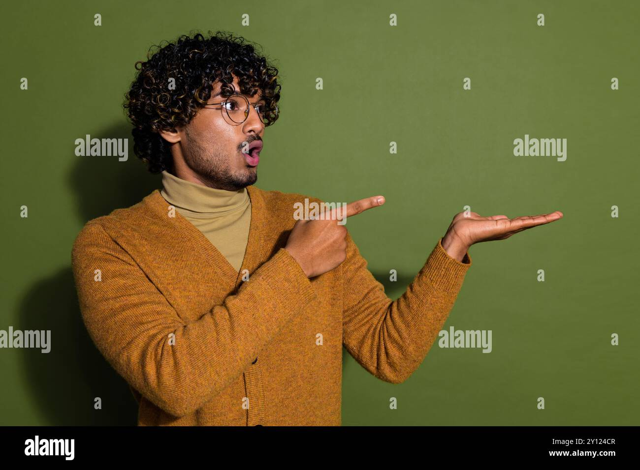 Photo portrait of handsome young guy point look hold shocked empty ...