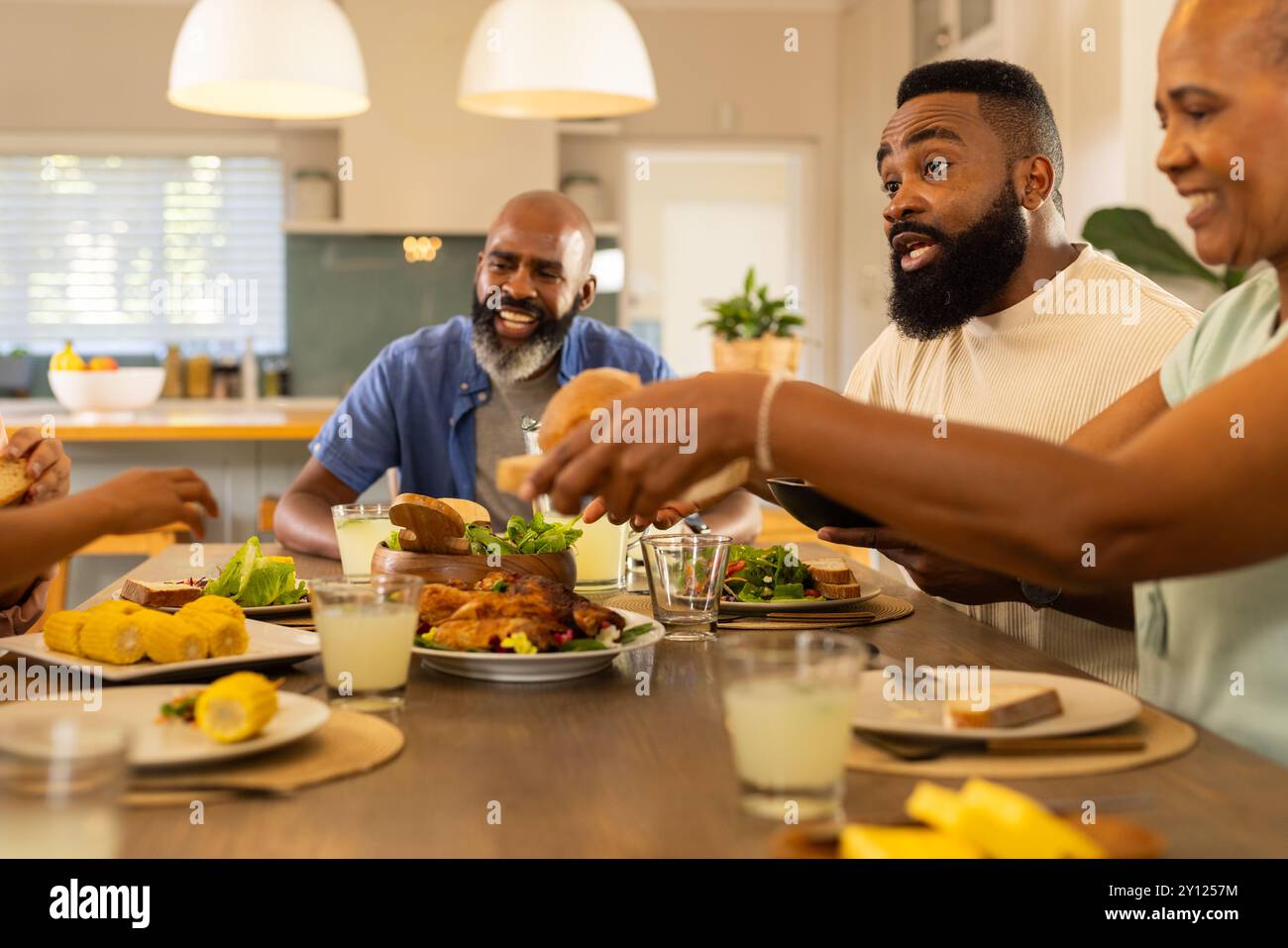 multigenerational family enjoying meal together, sharing food and ...