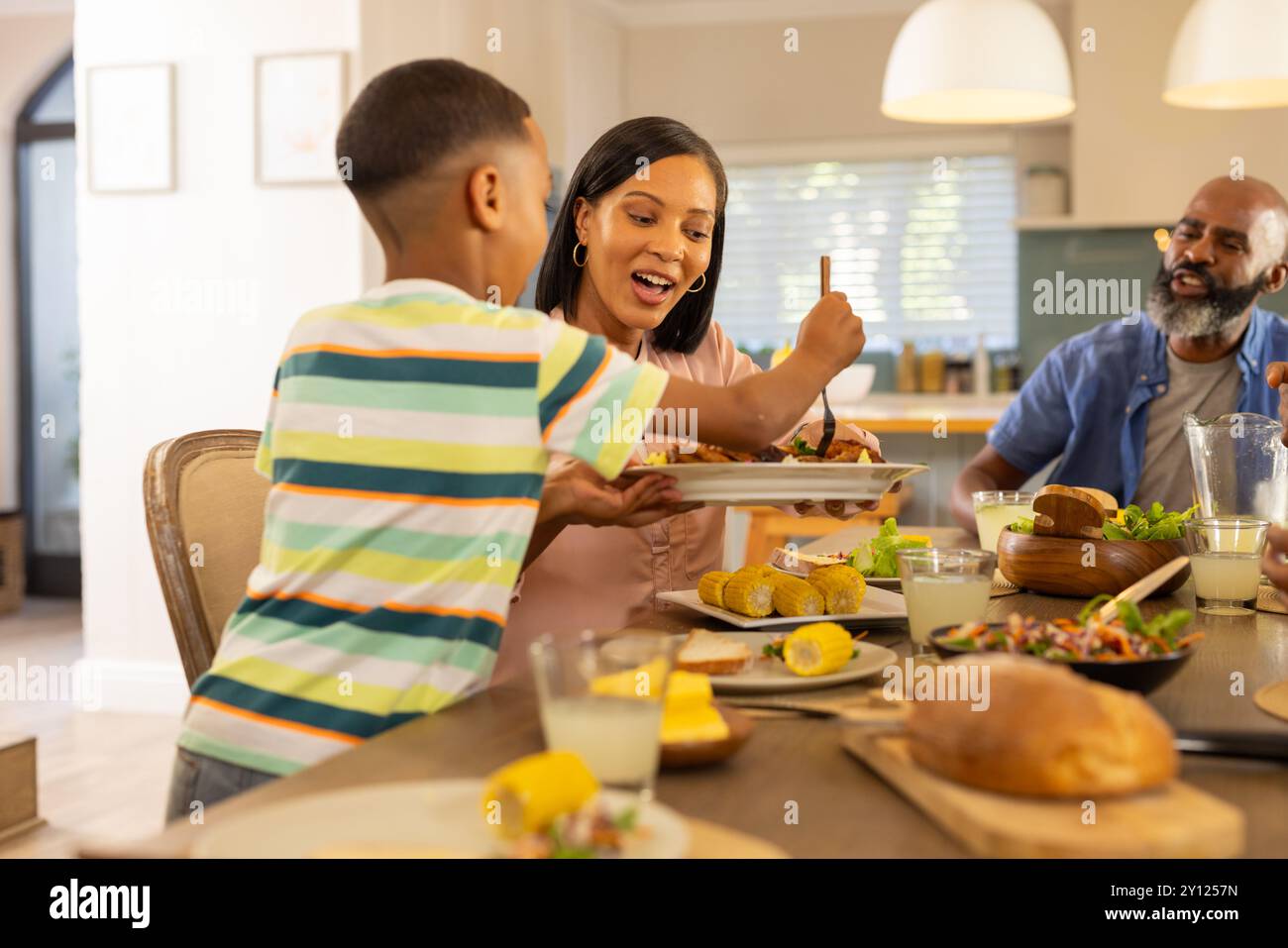 multigenerational family enjoying meal together at home, sharing food ...