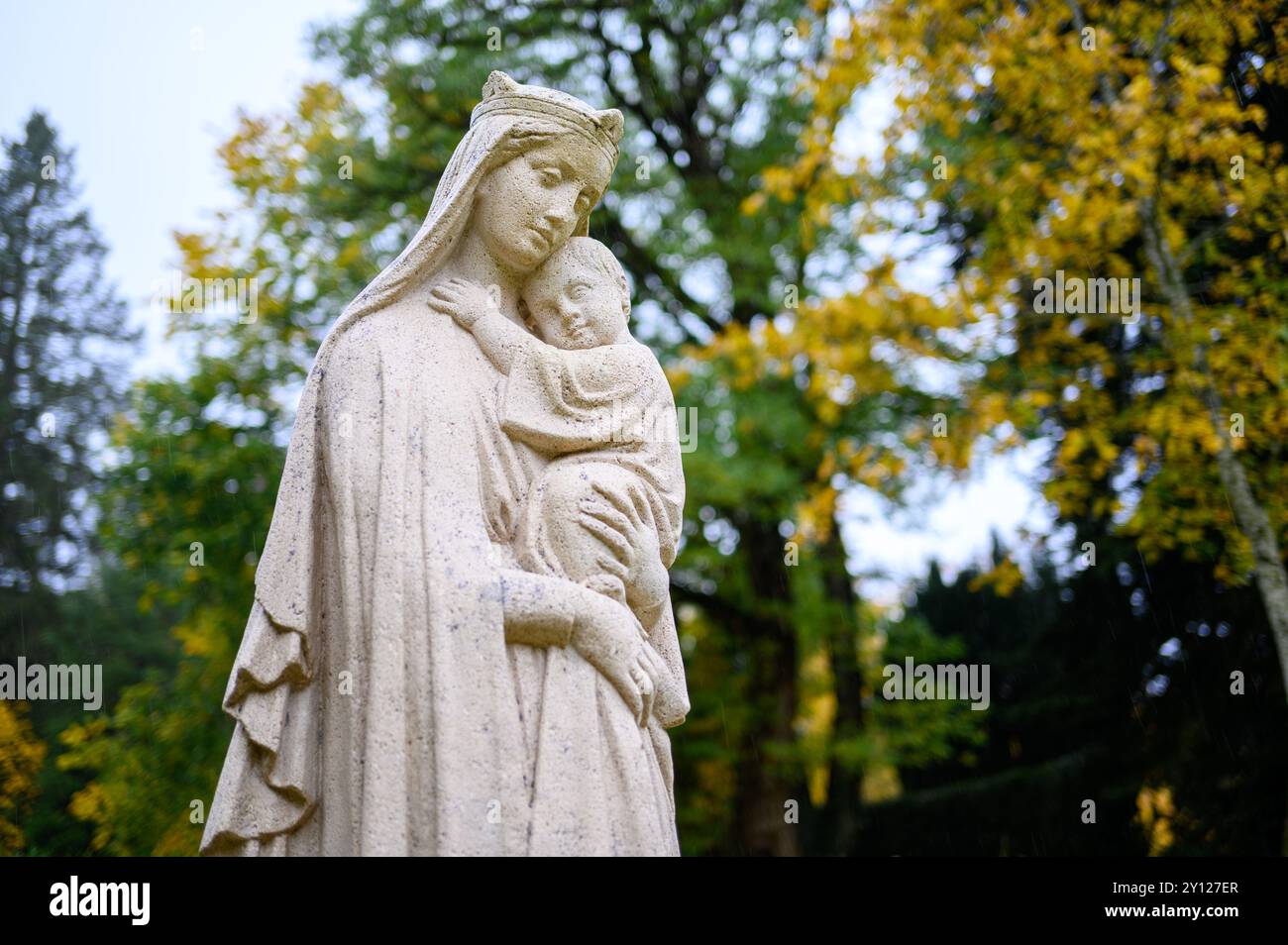 A statue of the Virgin Mary with the Infant Jesus in the park of the ...