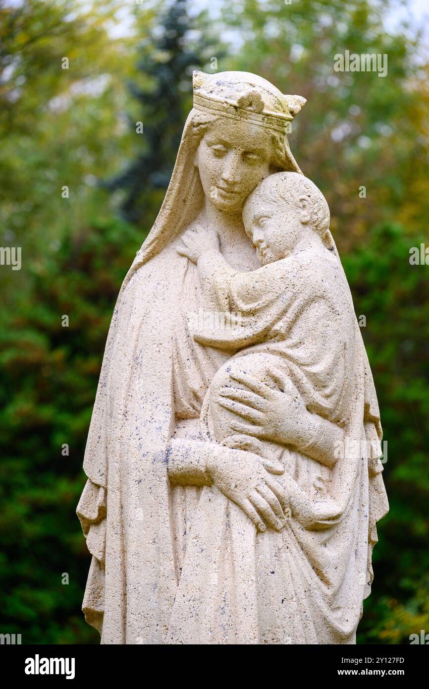 A statue of the Virgin Mary with the Infant Jesus in the park of the ...