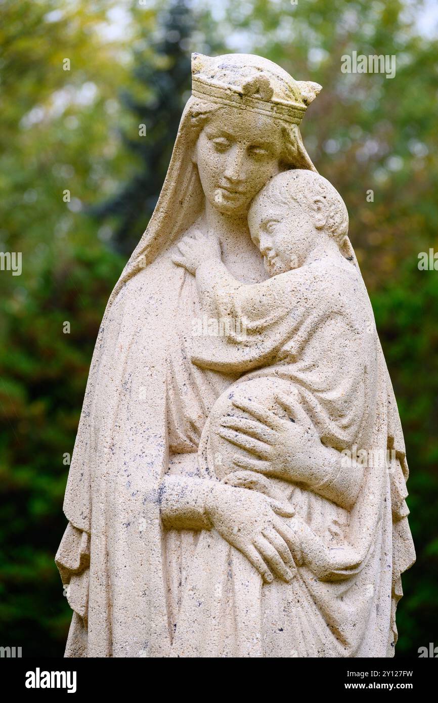 A statue of the Virgin Mary with the Infant Jesus in the park of the ...