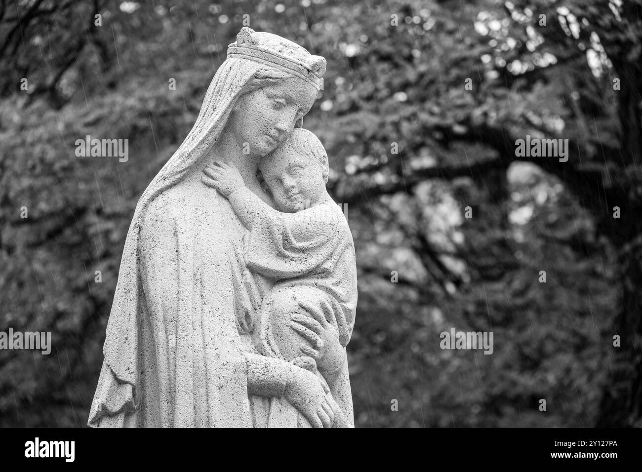 A statue of the Virgin Mary with the Infant Jesus in the park of the ...