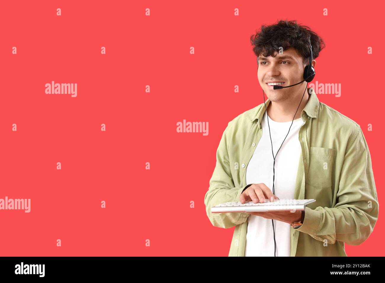 Male technical support agent with PC keyboard on red background Stock ...