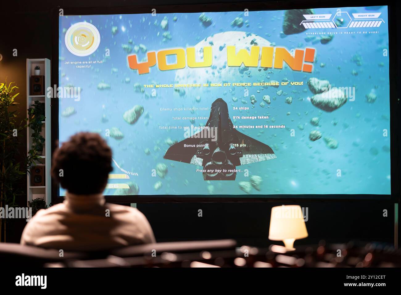 BIPOC man looking at winning screen of SF game on ultrawide smart TV ...