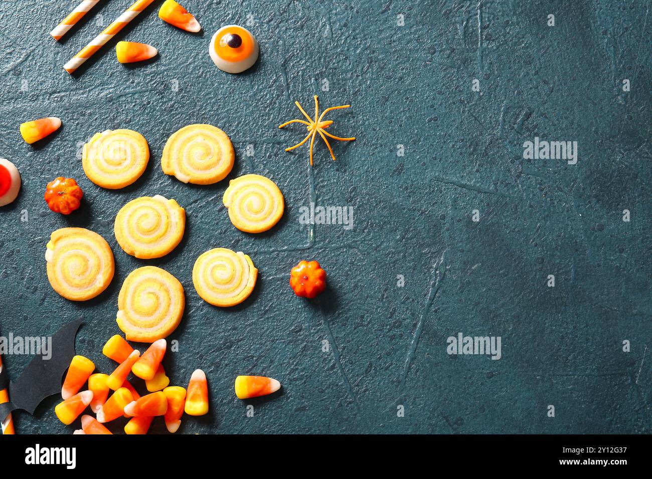 Tasty Halloween cookies with scary candies on grunge black background ...