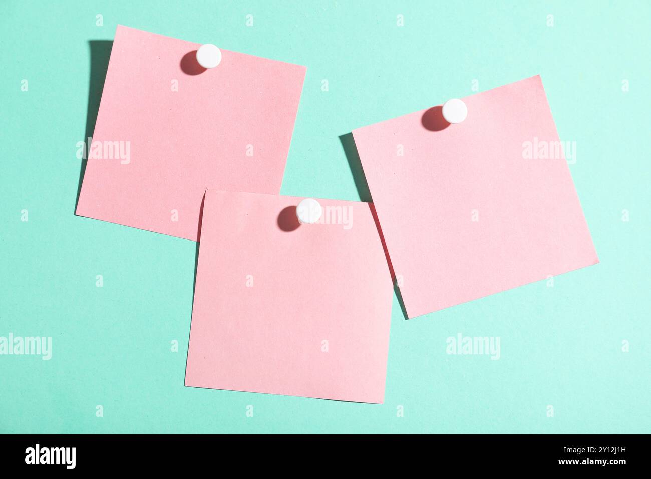 Pink paper notes pinned on turquoise background Stock Photo - Alamy