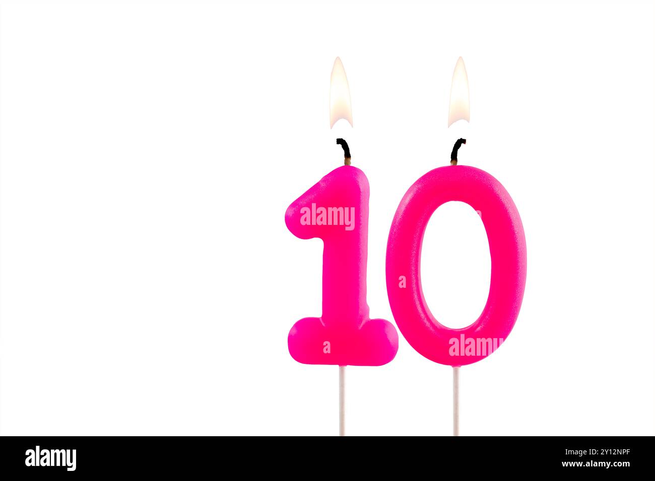 Pink number 10 birthday candle lit on white background Stock Photo - Alamy