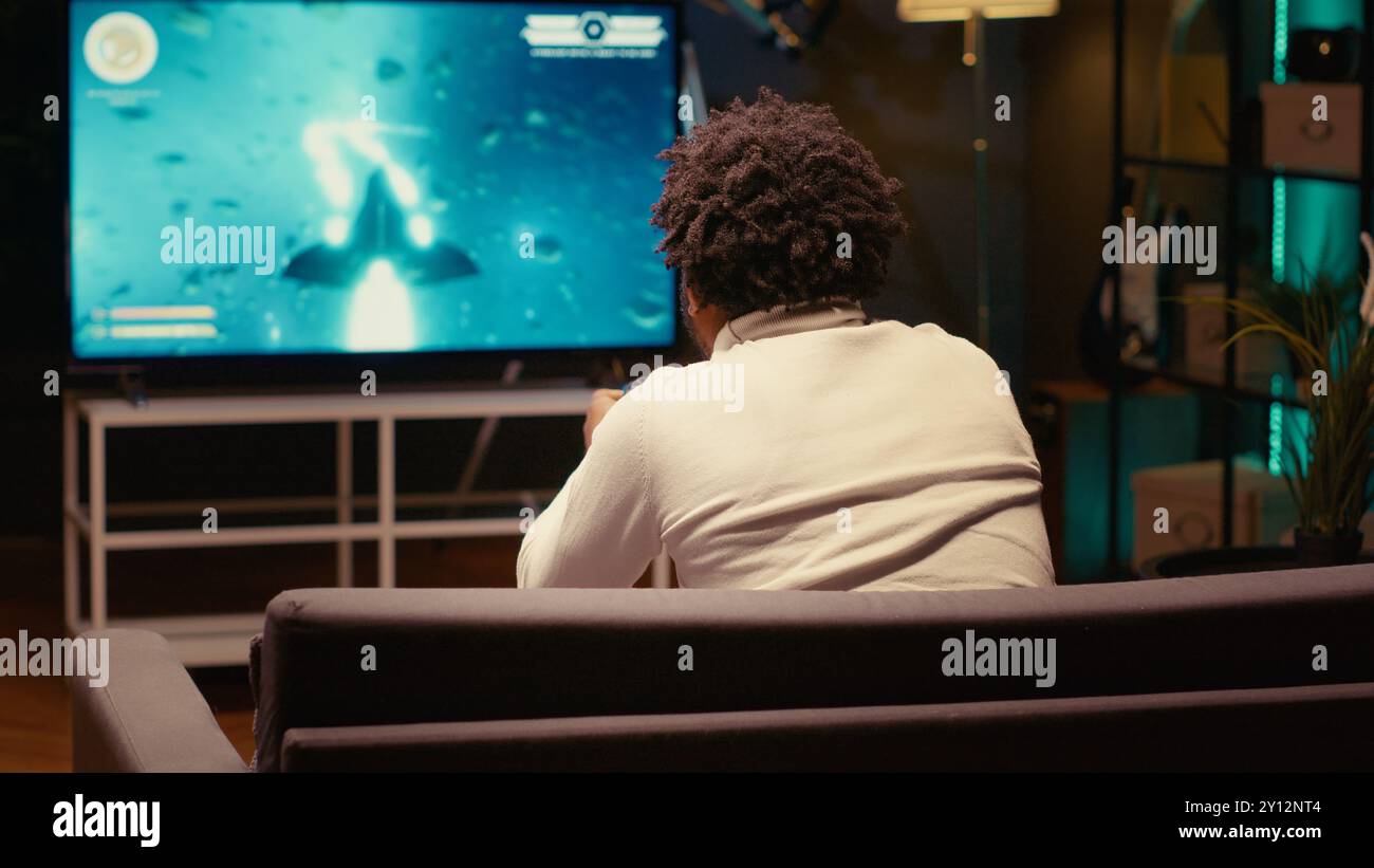 Gamer playing classic arcade space shooter videogame on big smart TV ...