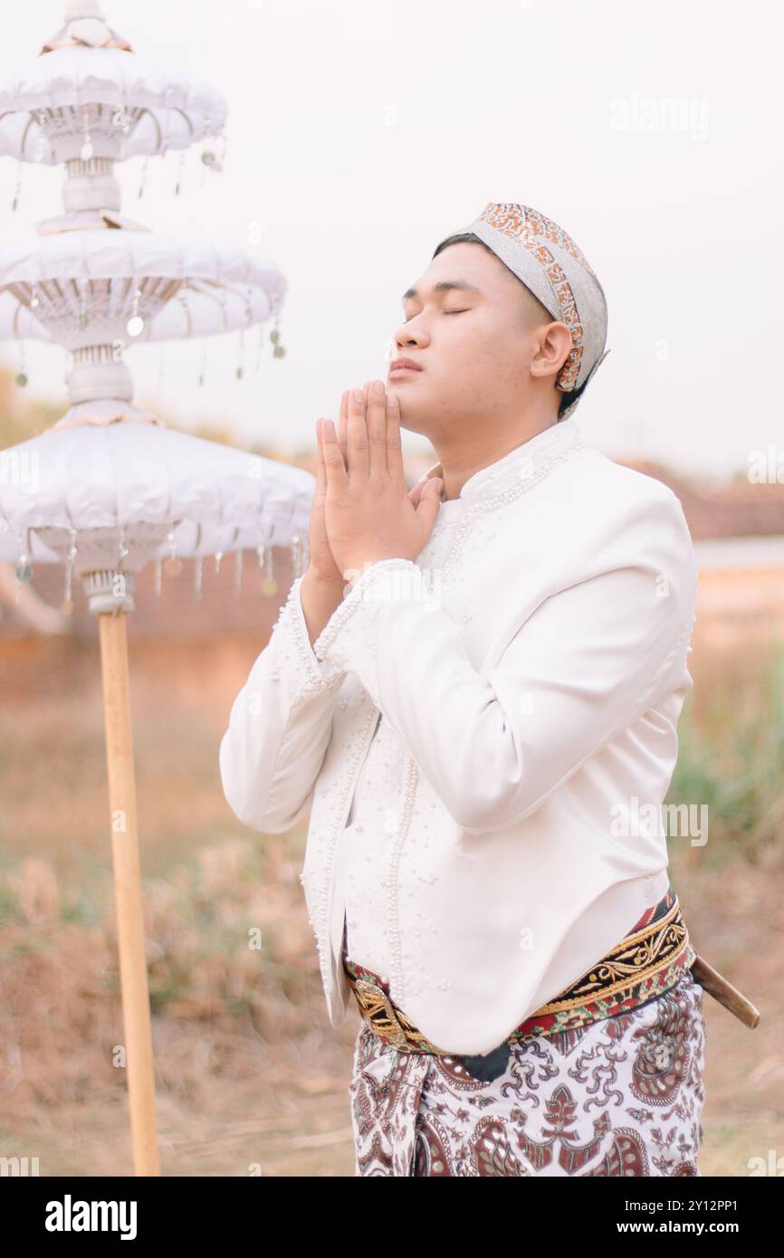 Handsome young indonesia man standing hands raising head wearing modern ...