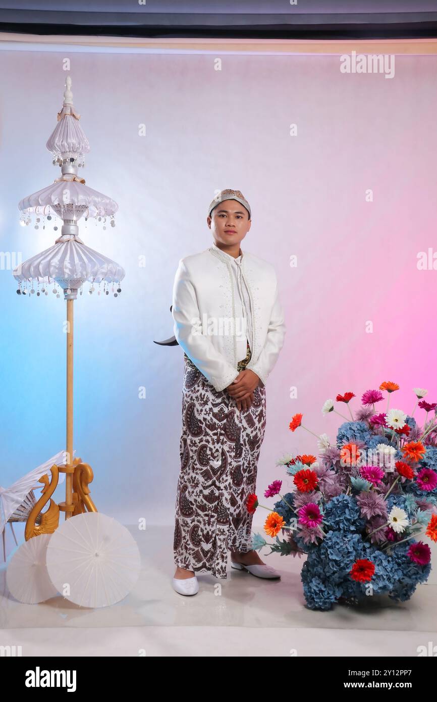 full body gallantry of young elegant Asian man standing among flower ...