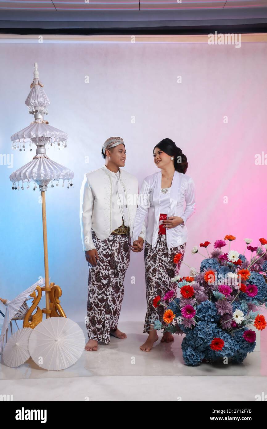 full length of a pair of indonesia men and women smiling at each other ...