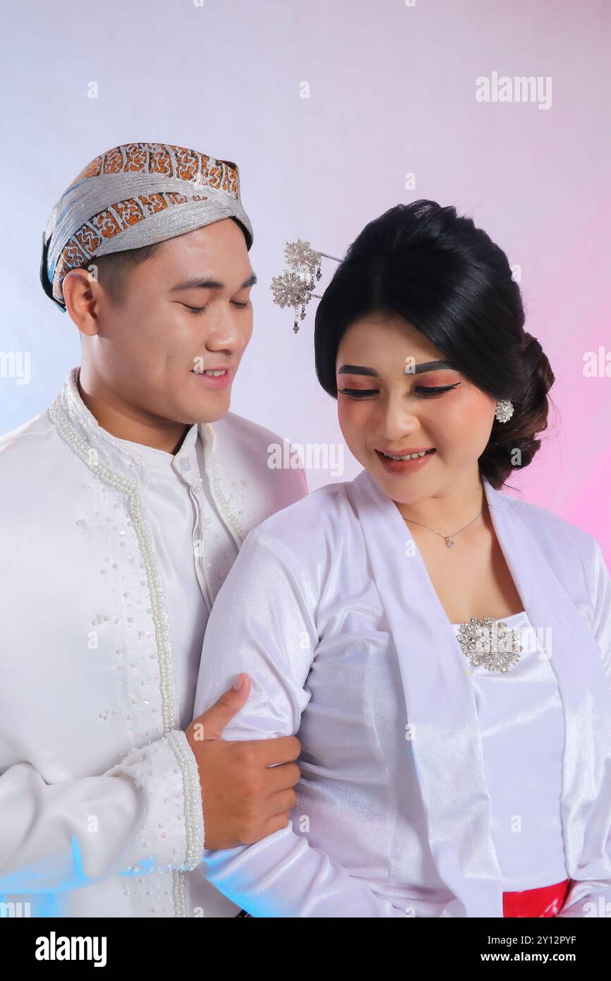 A pair of Asian lovers, boy and girl, smiling shyly, the man's hand ...