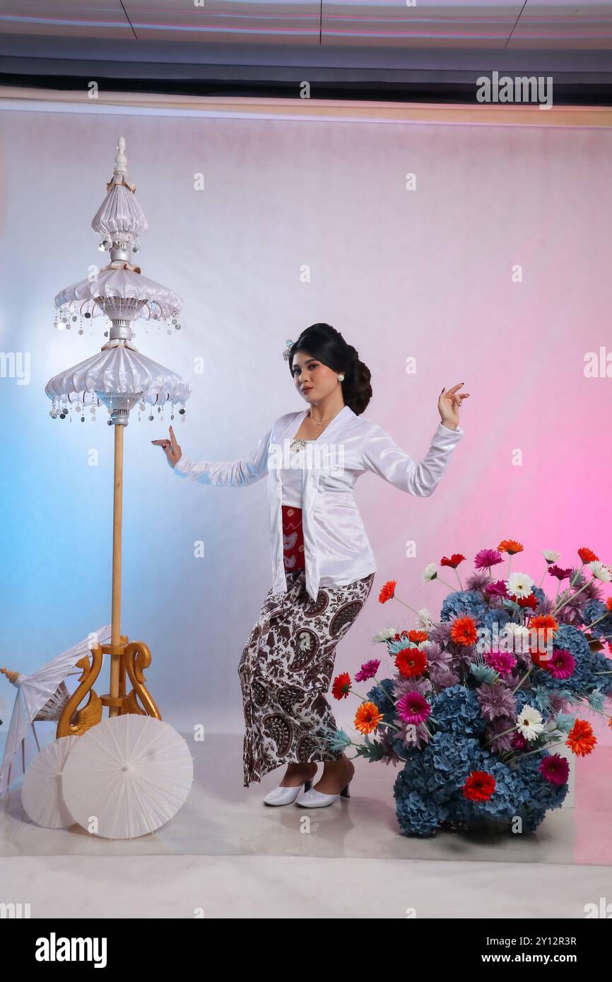 Full body of adult Asian woman standing dancing wearing modern Javanese ...