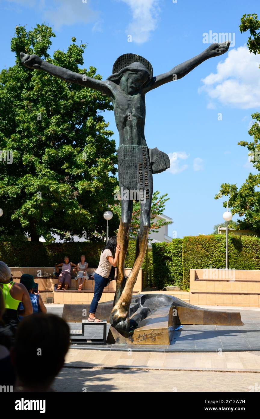 People venerating the statue of the Risen Christ in Medjugorje. The ...