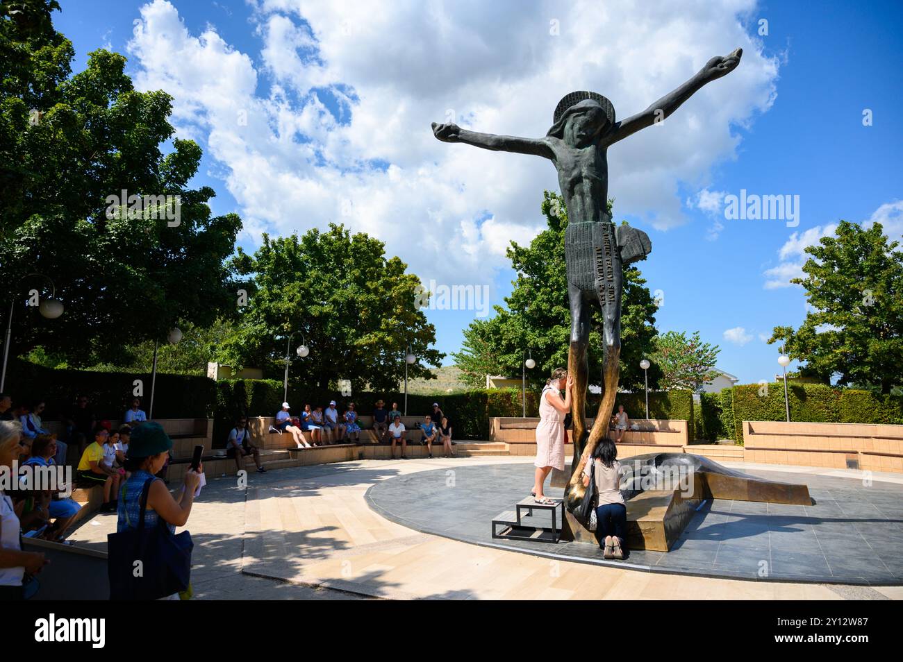 People venerating the statue of the Risen Christ in Medjugorje. The ...