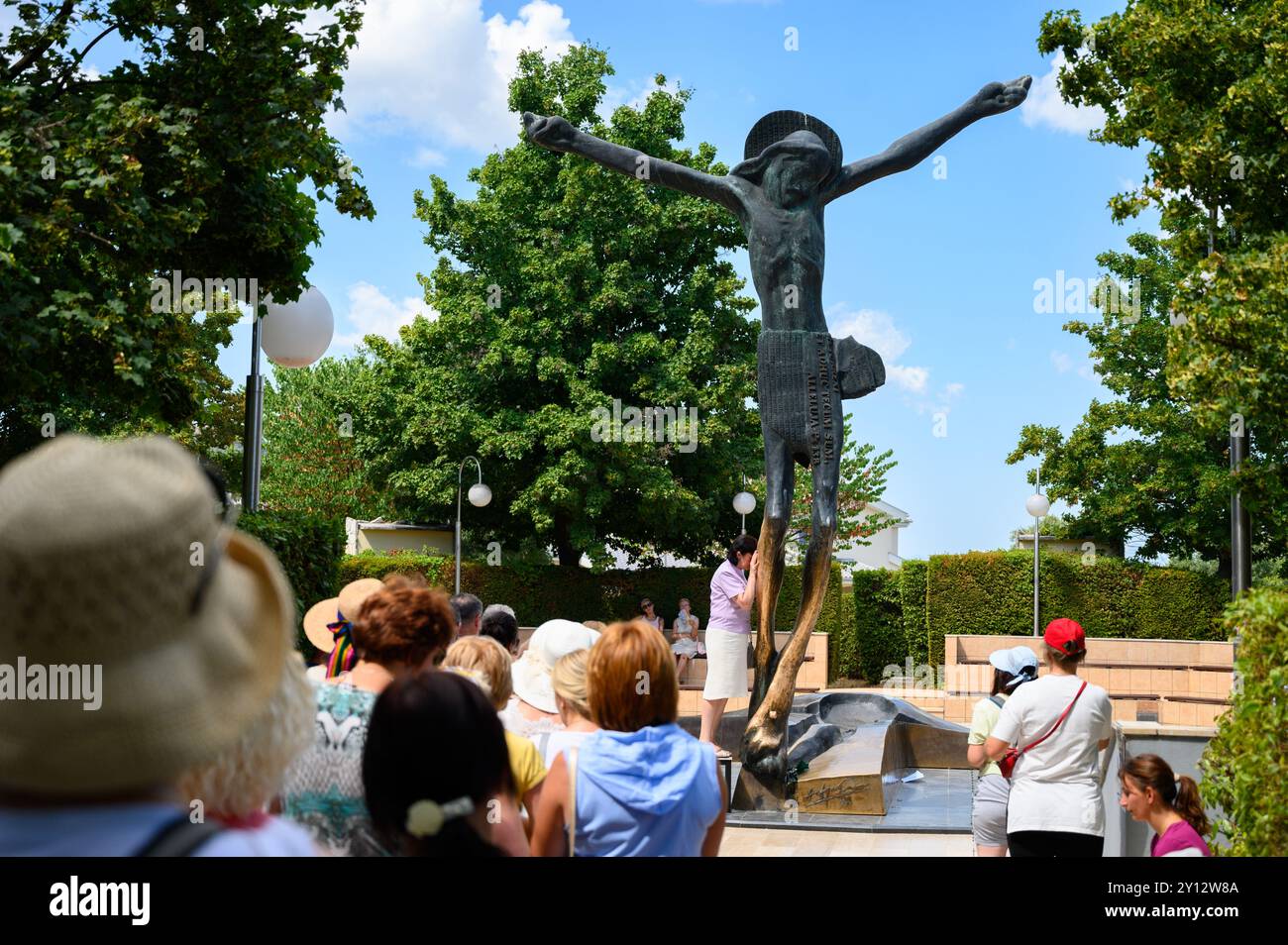 People venerating the statue of the Risen Christ in Medjugorje. The ...