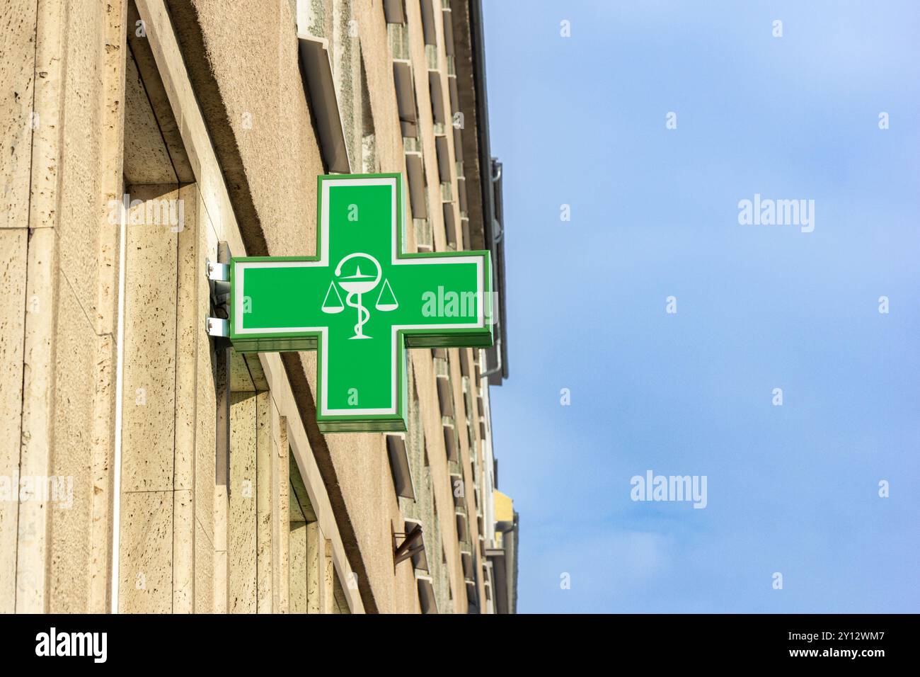 a green pharmacy cross (with a snake coiled around a cup and scales) –a ...