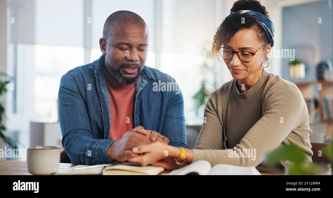 Couple, holding hands and praying with bible as Christian for spiritual ...