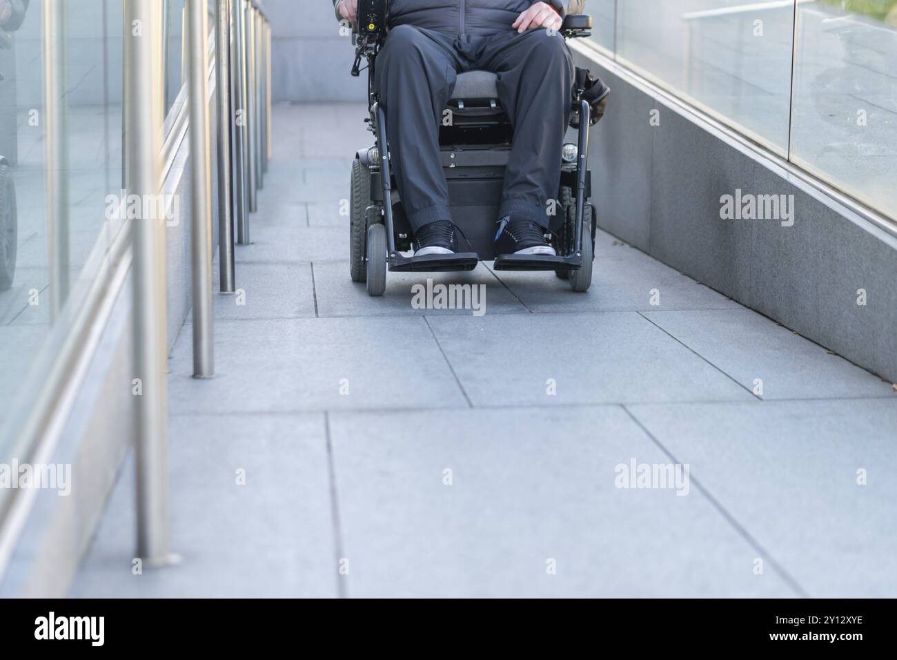 Man in a wheelchair using a ramp next to stairs Stock Photo - Alamy