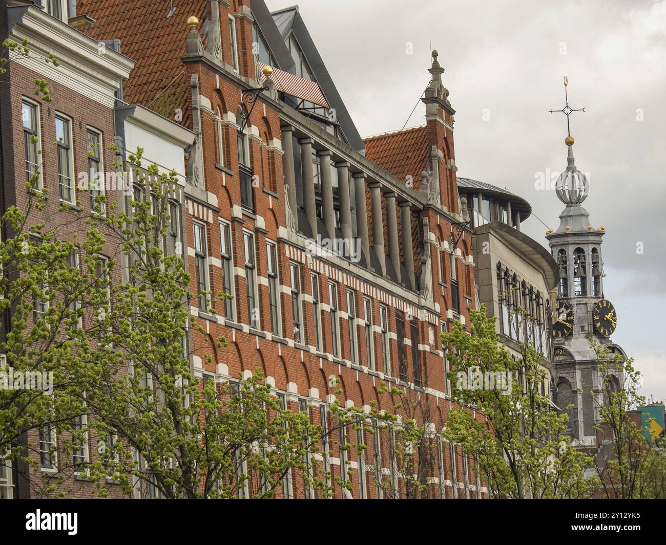 Street scene with large red brick buildings and a tower with a clock ...