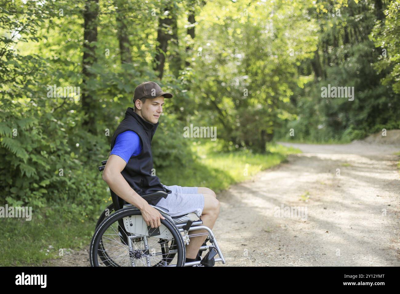 Happy and young disabled or handicapped man sitting on a wheelchair in ...