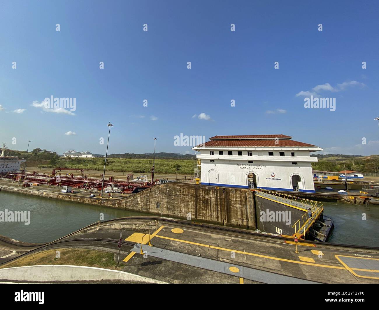 White lock building with red roof in an industrial canal area, panama ...